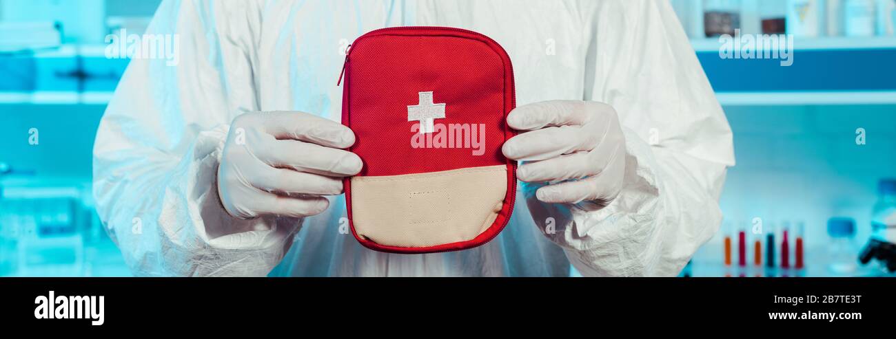 panoramic shot of scientist in hazmat suit holding first aid kit Stock ...