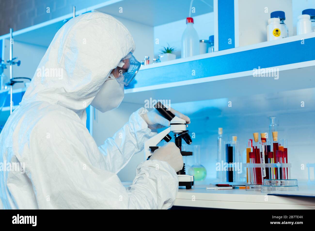 scientist in hazmat suit and goggles near microscope Stock Photo - Alamy