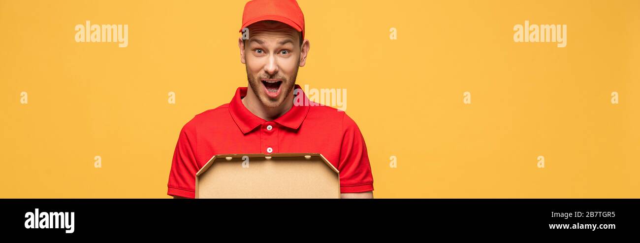 shocked delivery man in red uniform holding pizza box isolated on ...
