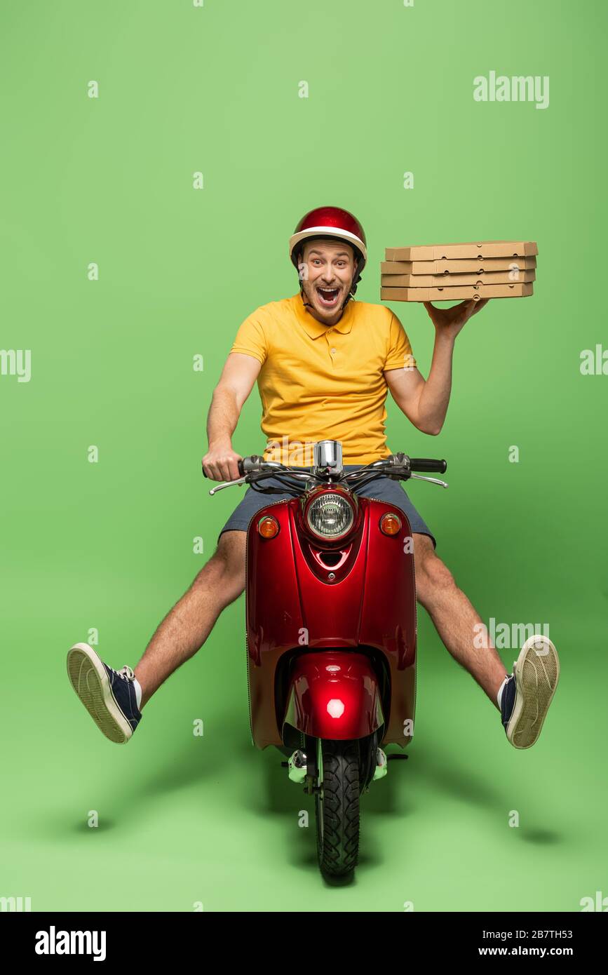 crazy delivery man in yellow uniform on scooter delivering pizza on ...