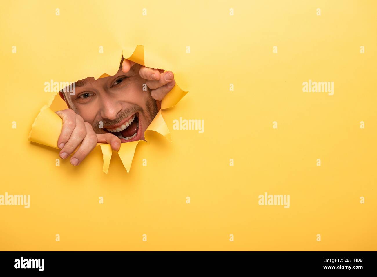 Man looking through ripped paper hole hi-res stock photography and ...