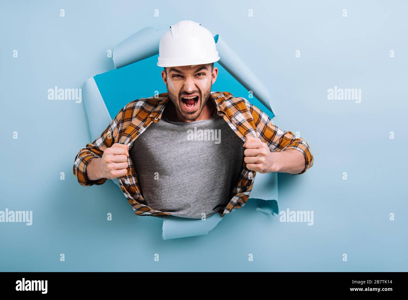 angry foreman in yelling in torn paper, isolated on blue Stock Photo ...