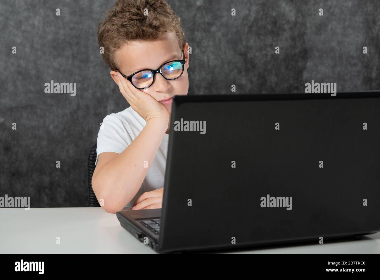 a serious boy sitting with laptop computer Stock Photo - Alamy