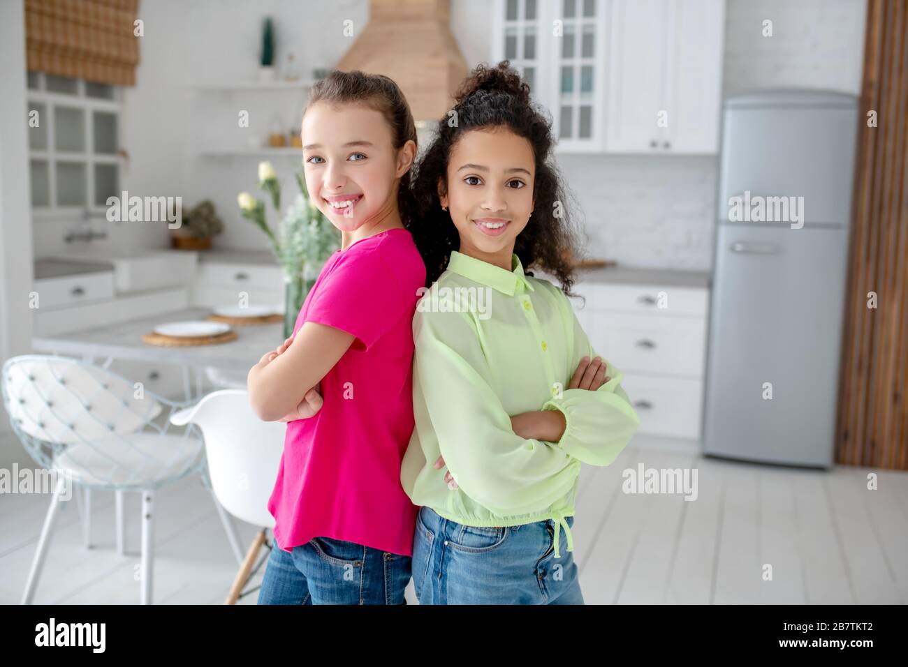 Two friends standing in the kitchen back to back Stock Photo - Alamy