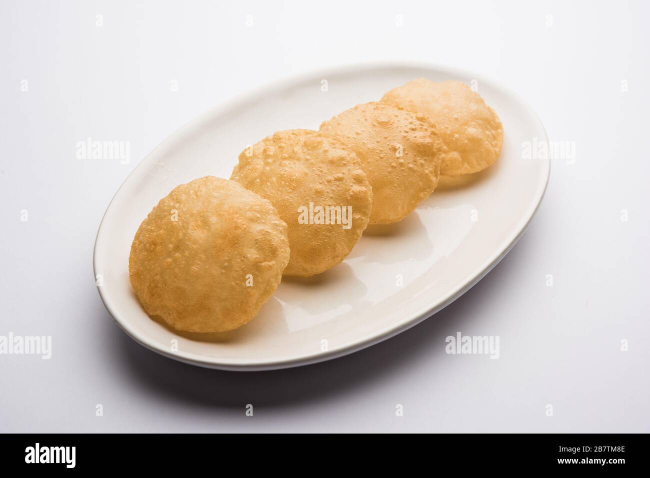 Plain Puri served in a plate. It's an Indian deep-fried bread made from ...