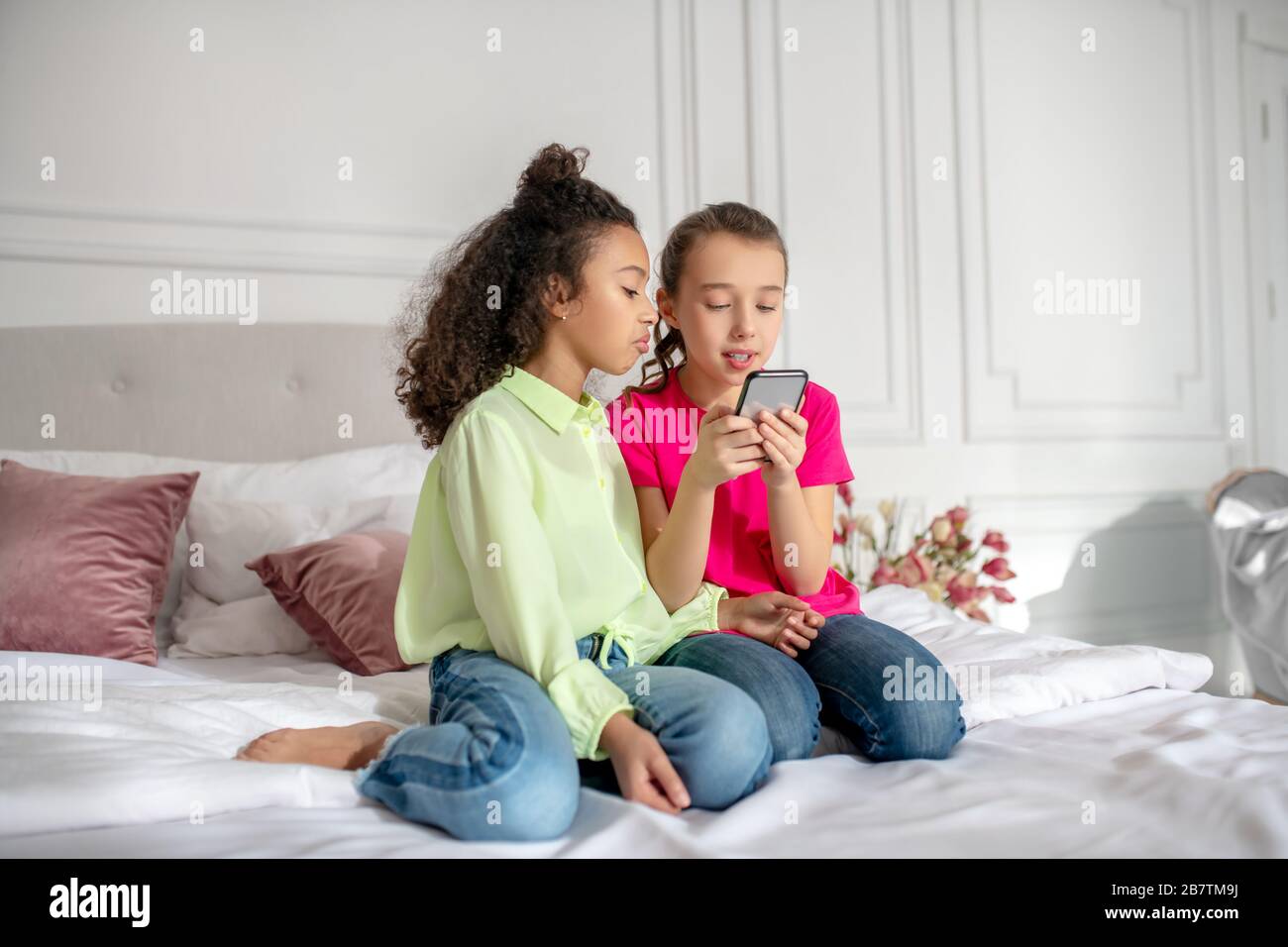 Two girls watching video online and looking interested Stock Photo - Alamy