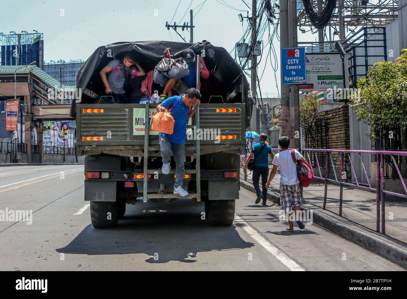 Makati City. 18th Mar, 2020. People disembark from a military truck ...