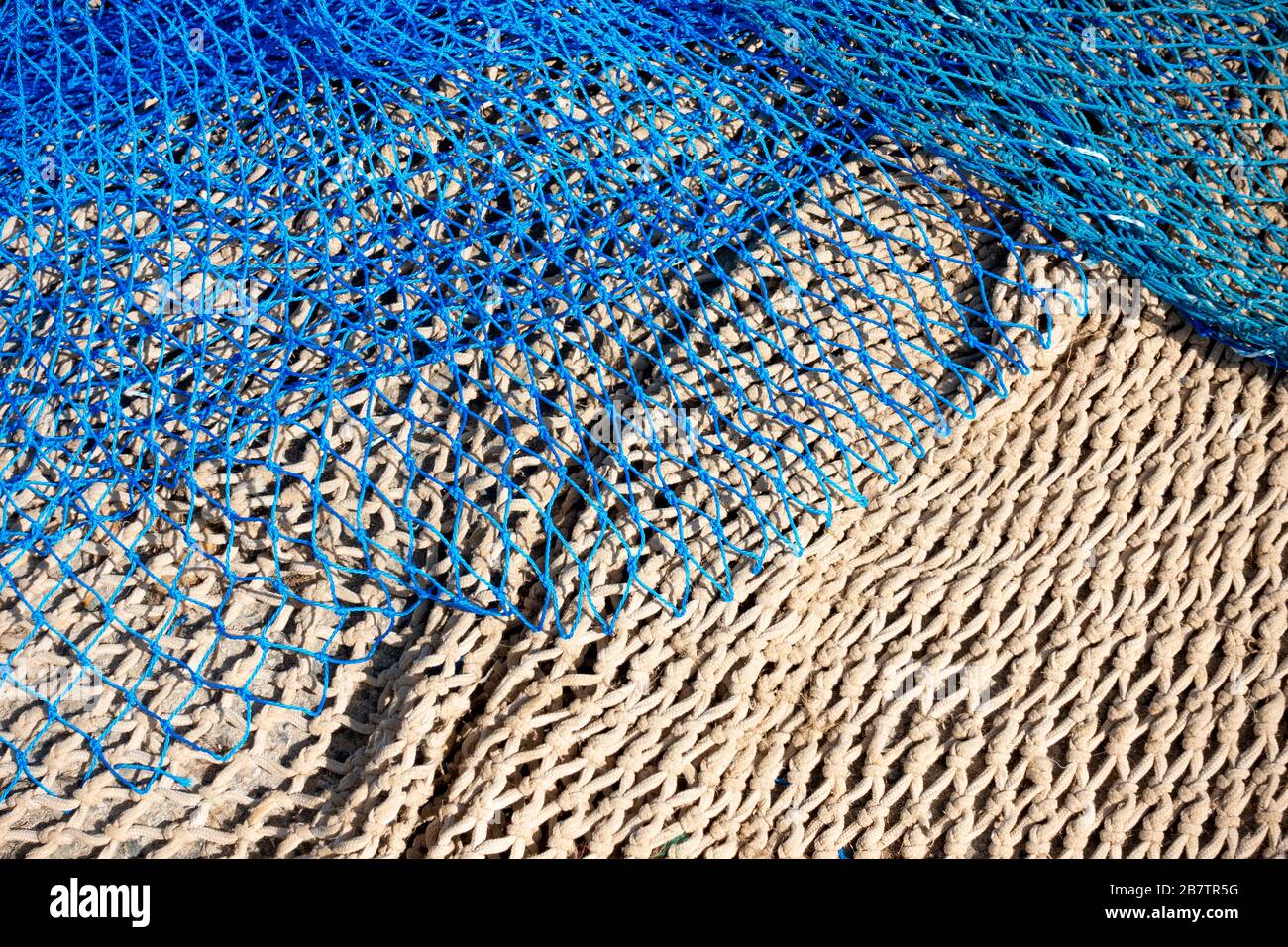 Commercial beige and blue color fishing nets background Stock Photo - Alamy