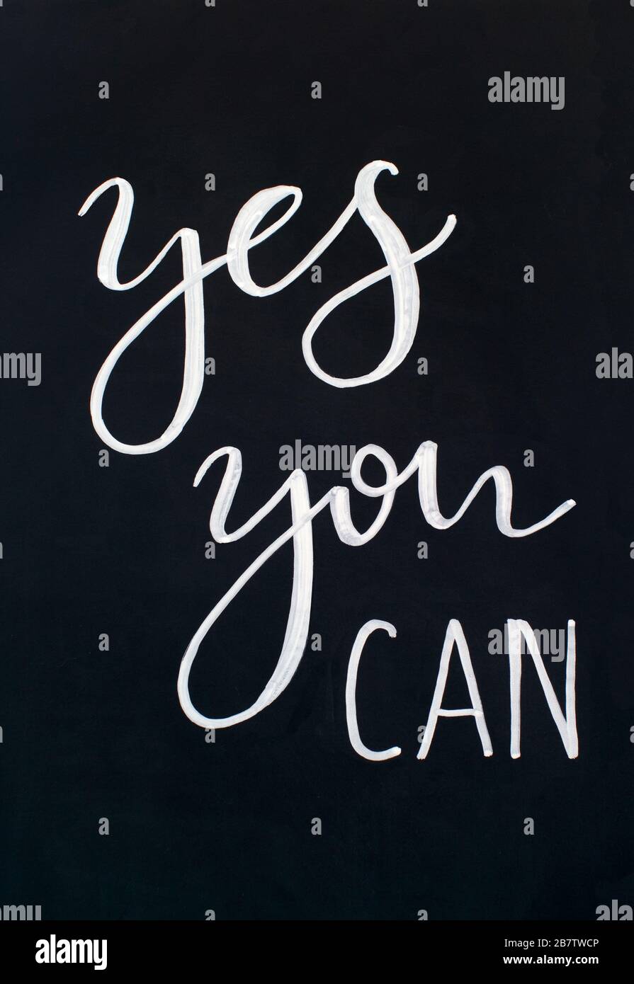 Chalk inscription YES YOU CANon a black chalkboard. Handwritten ...