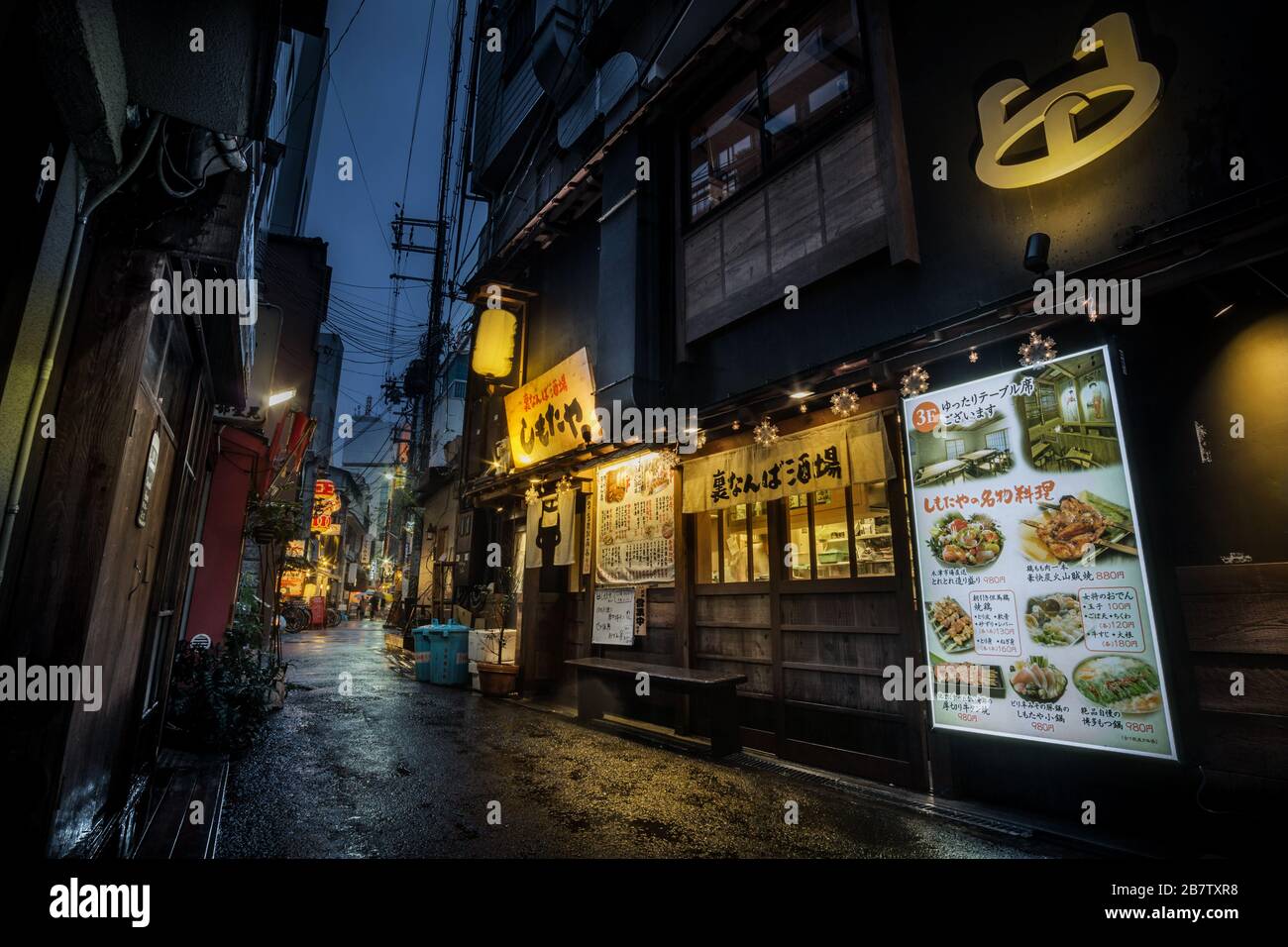 View of a restaurant in a narrow alley on a rainy evening in Osaka ...