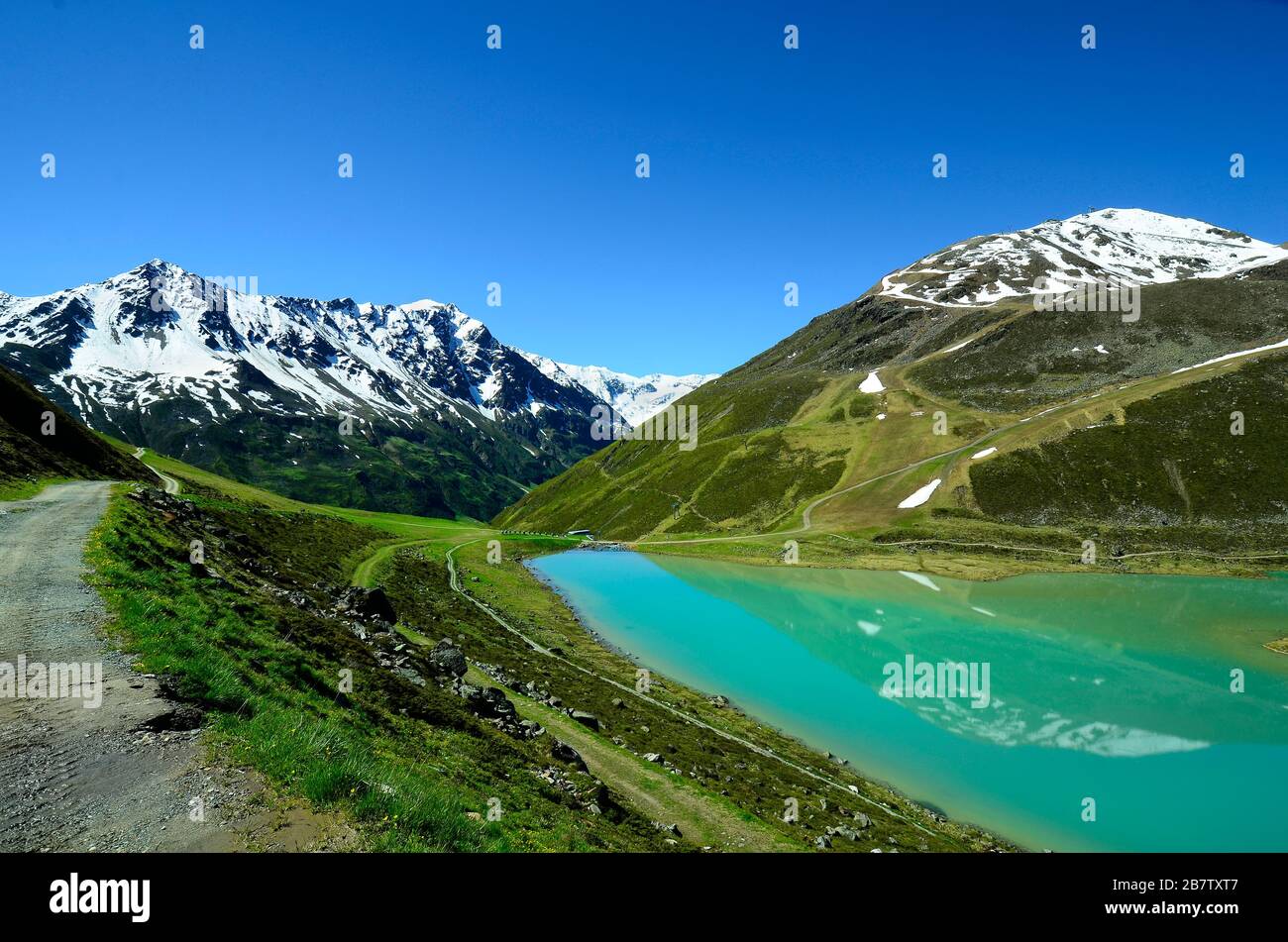 Austria, Tirol, Rifflsee - lake and snow remains in Tyrolean Alps ...