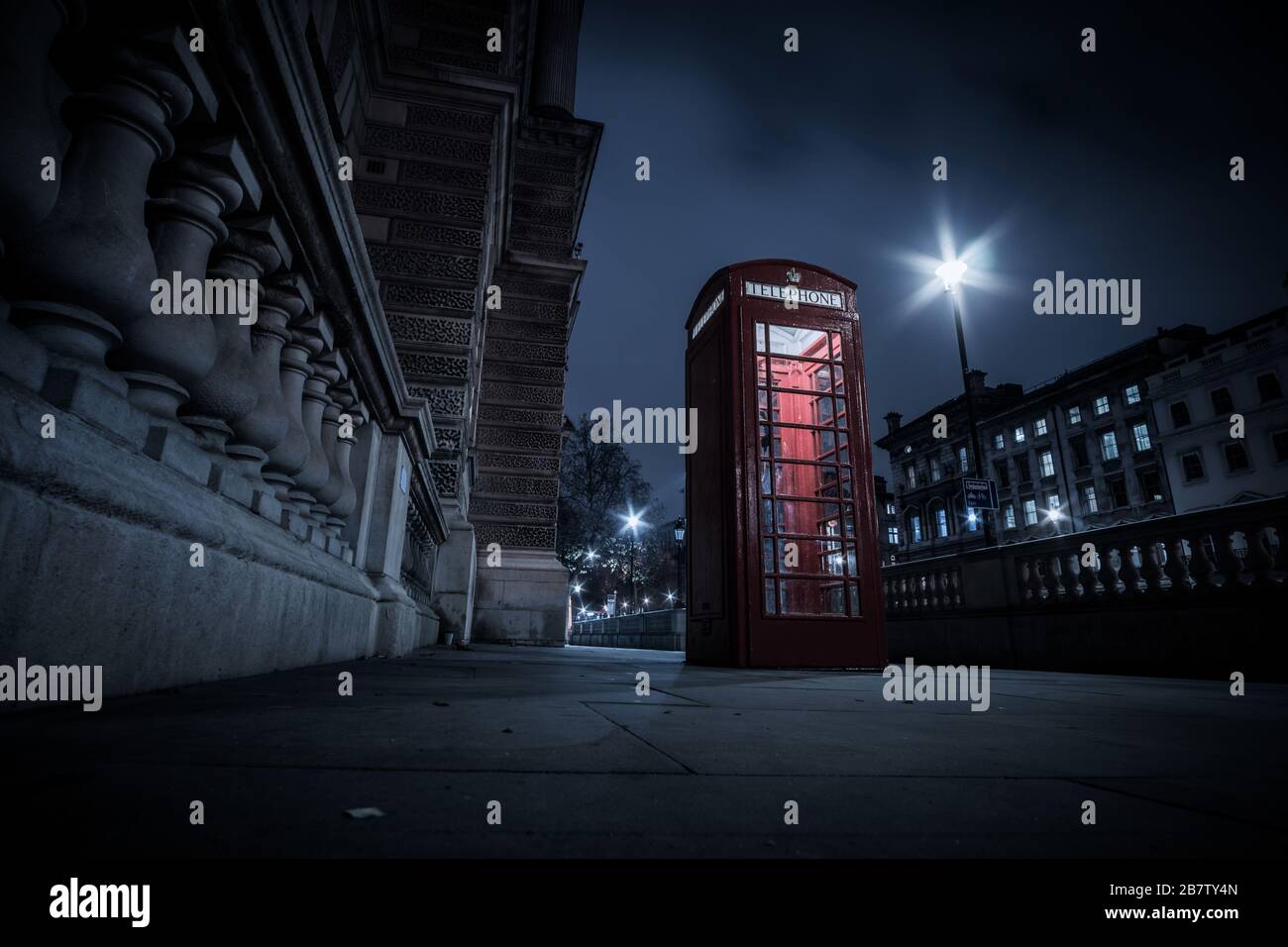 Night view of an old red British telephone box in Whitehall, London ...
