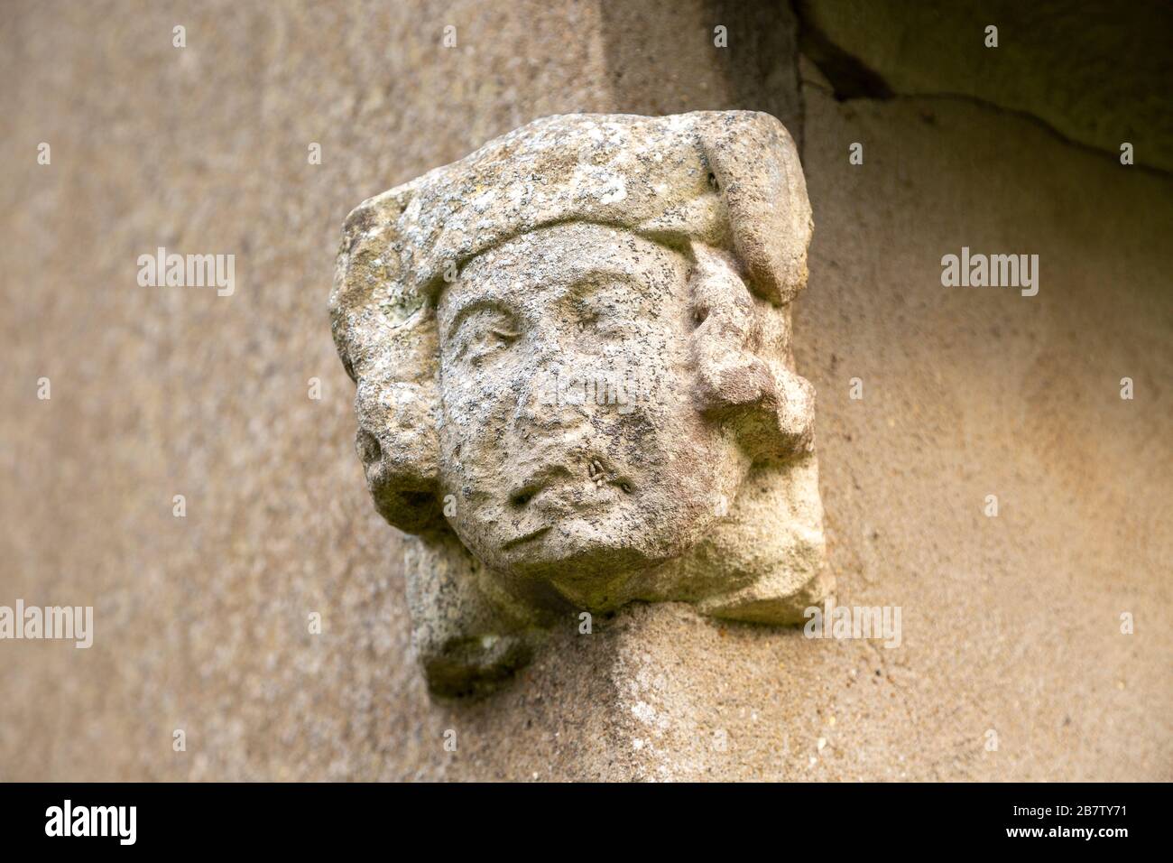 Carved stone head and face weathered figure on exterior of Brantham ...