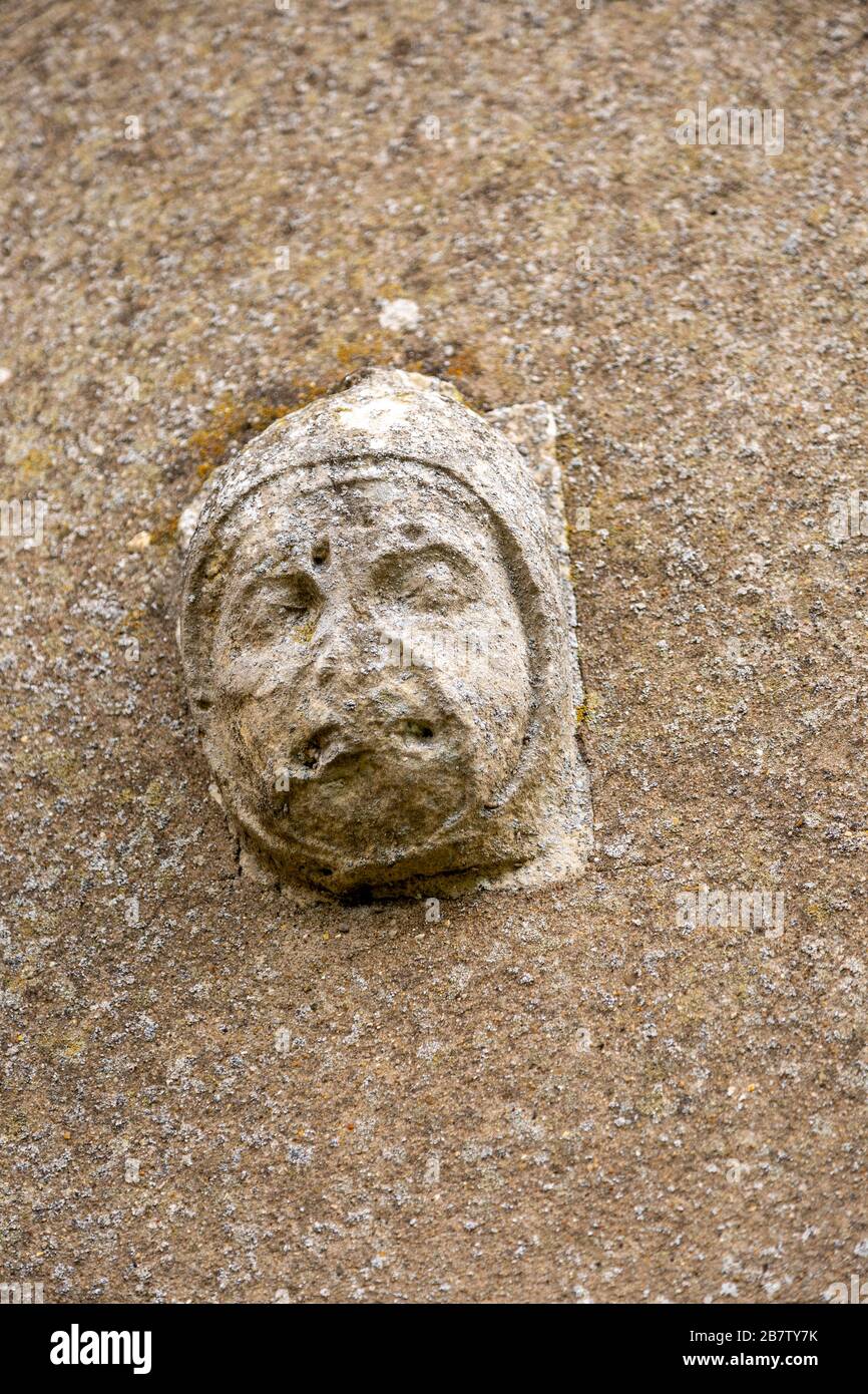 Carved stone head and face weathered figure on exterior of Brantham ...