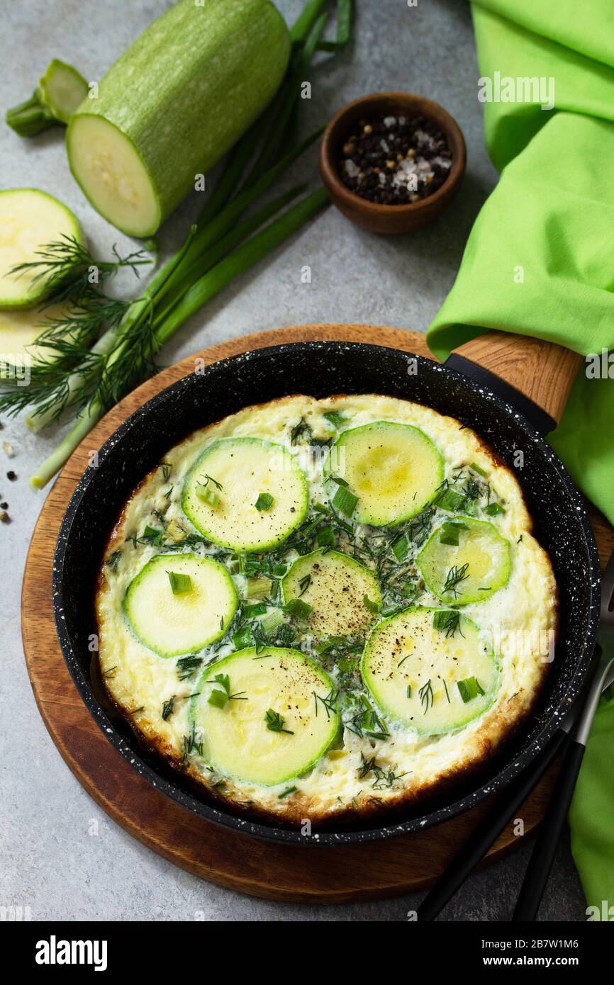 Breakfast. Summer omelet with zucchini and herbs on a stone or slate ...