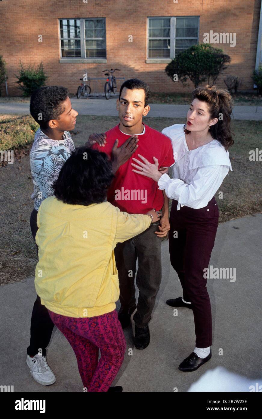 Friends of aggressive teen hold him back from a fight at high school ...
