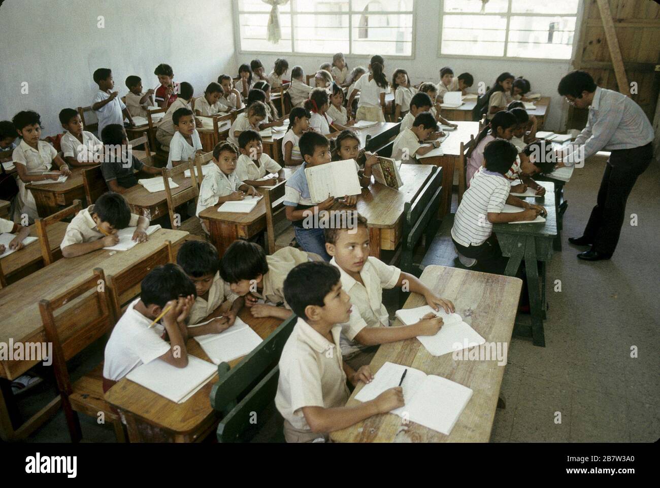 Honduras: Male teacher works with students in crowded primary school ...