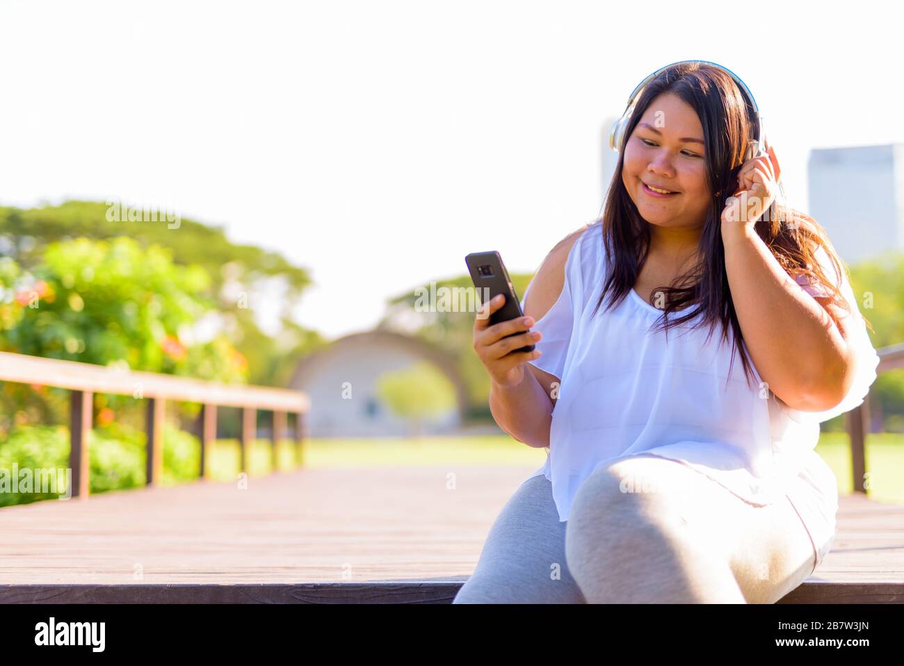 Beautiful overweight Asian woman relaxing at the park Stock Photo - Alamy