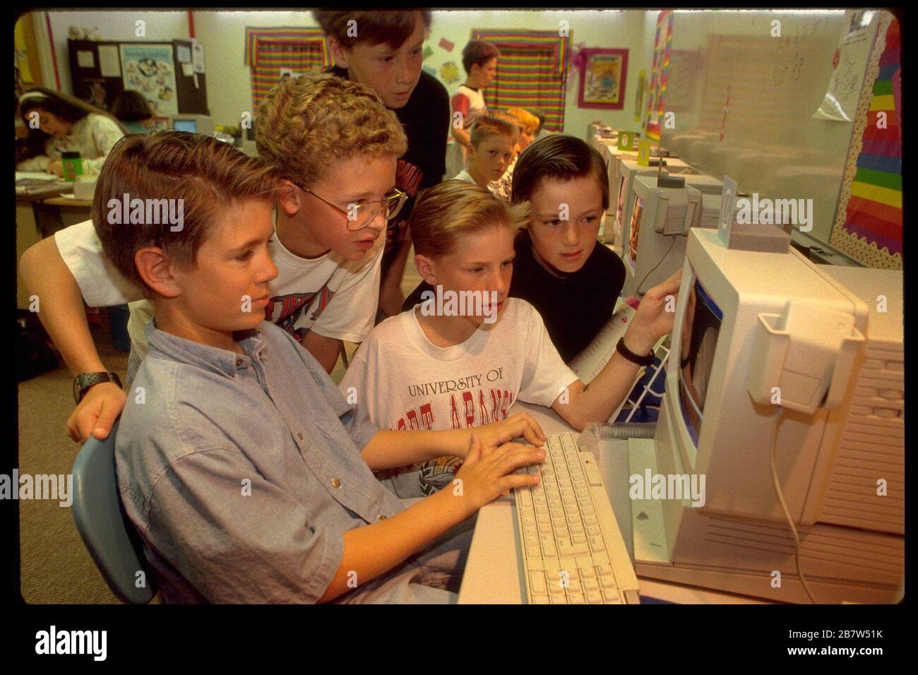 Lake Travis Texas USA: Boys crowd around desktop computer in computer ...