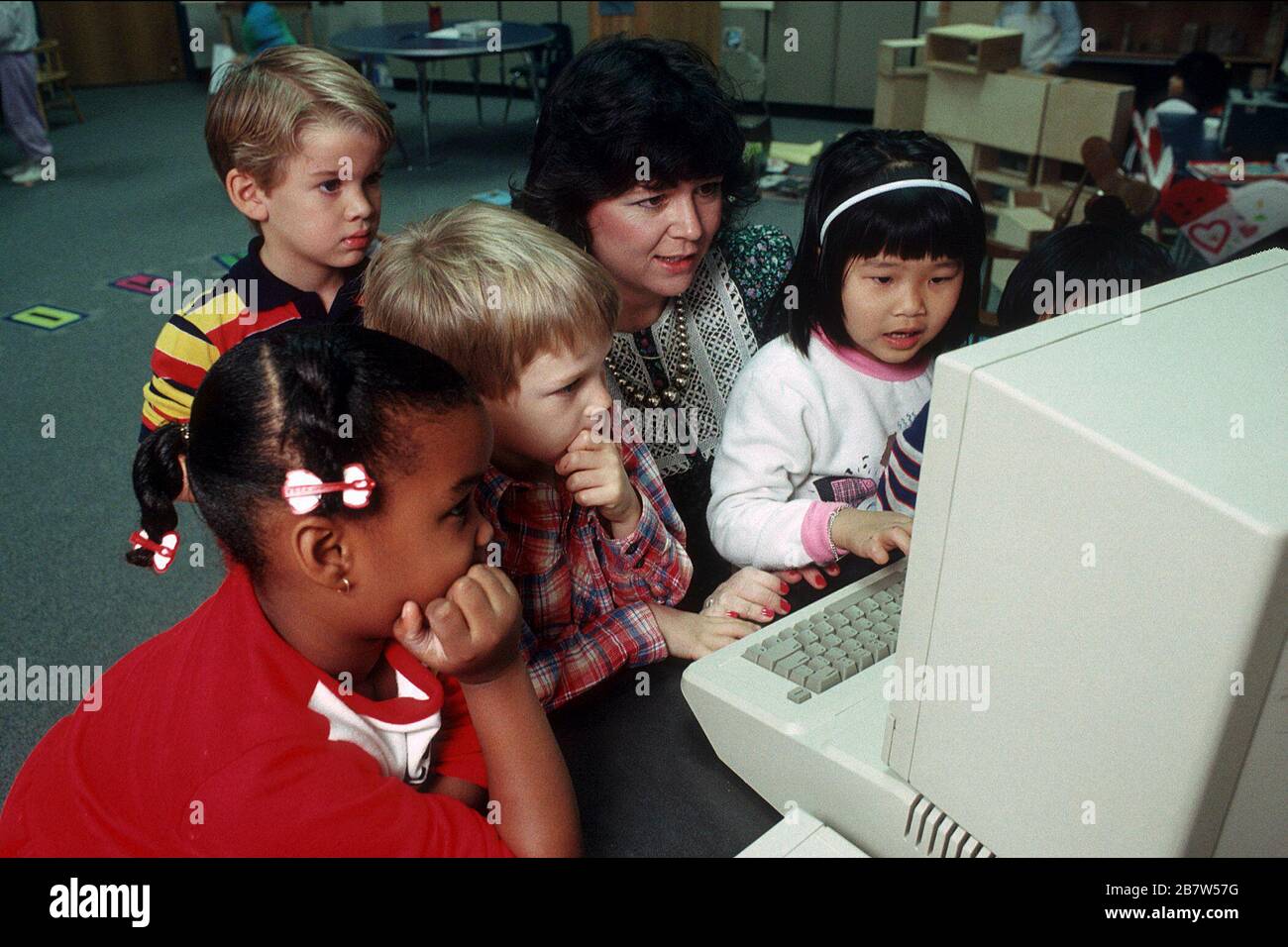 Austin Texas USA: Children crowd around teacher during computer class ...