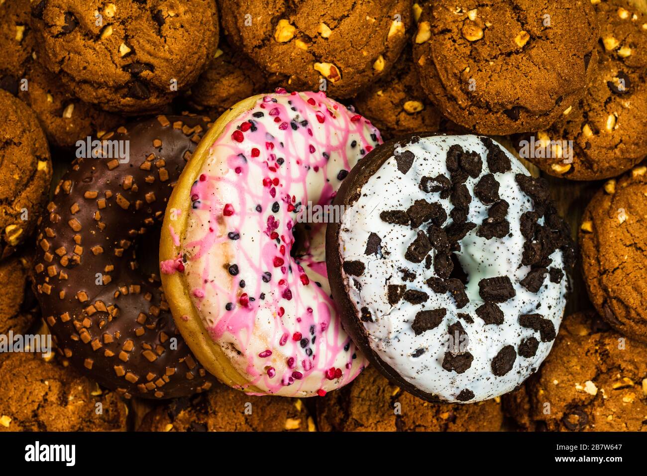 Chocolate chip cookies, biscuits and colorful donuts. Top view and ...
