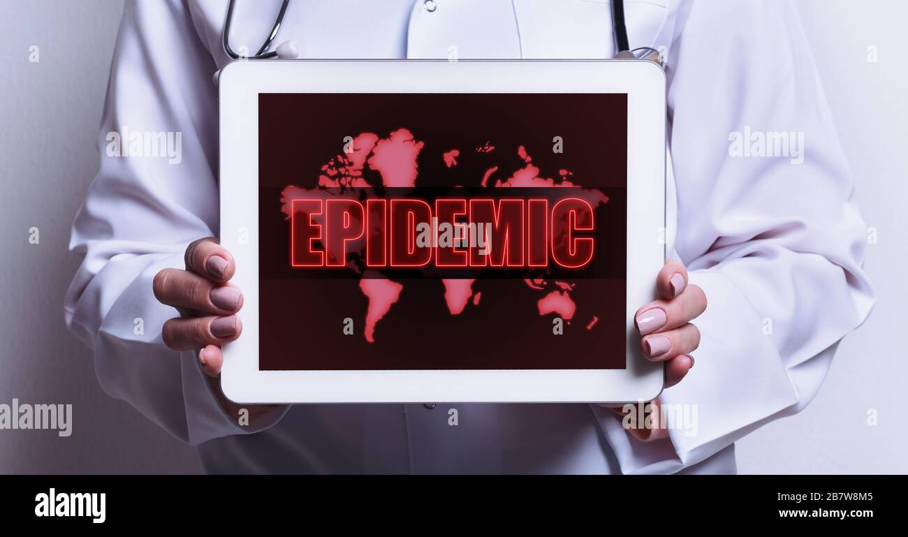Medic holding tablet computer with world map and word EPIDEMIC on ...