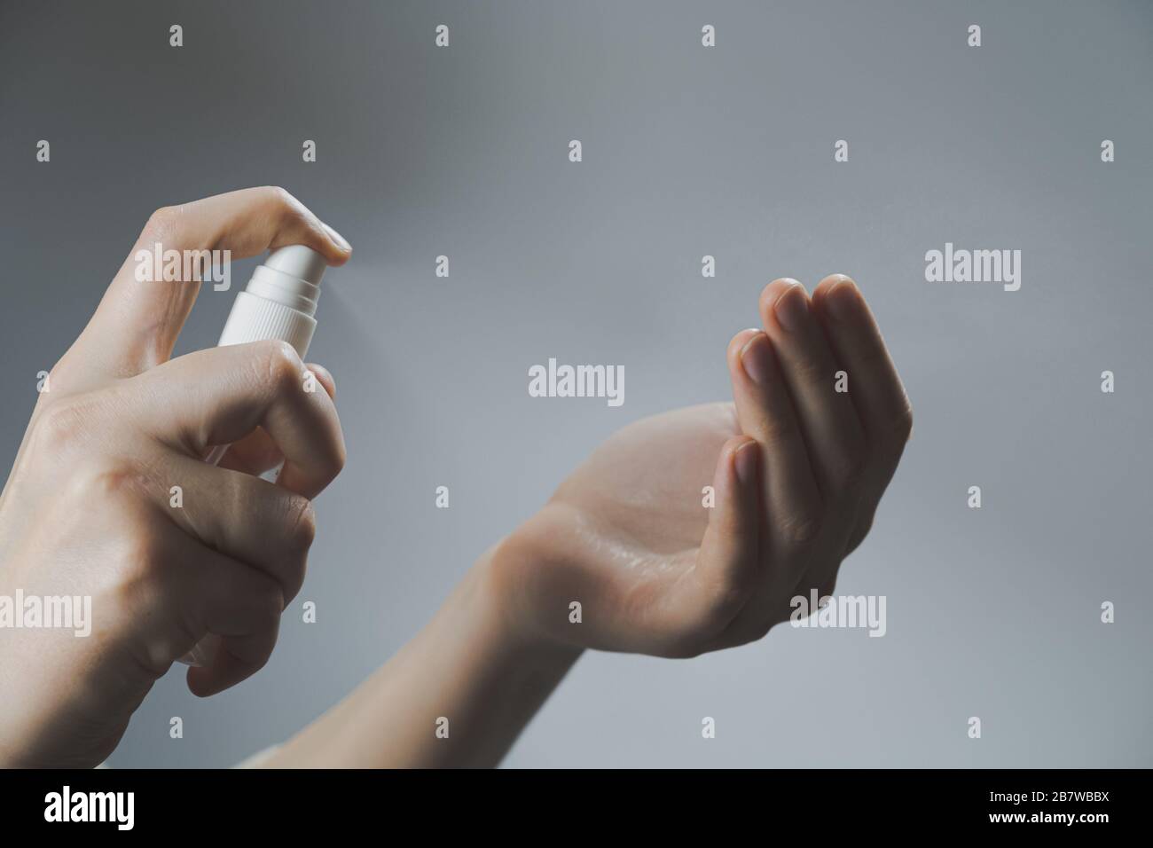 Cleaning hands with a personal sanitizer. Spraying hands, protection ...