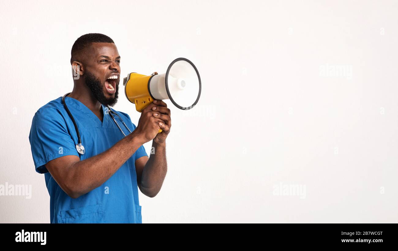 Angry black doctor in blue uniform using speaker Stock Photo - Alamy