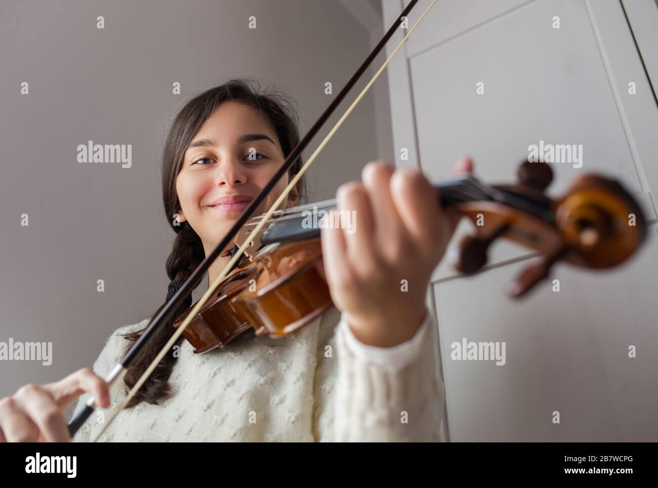 Young student smiling practice violin at home, seen from below Stock ...
