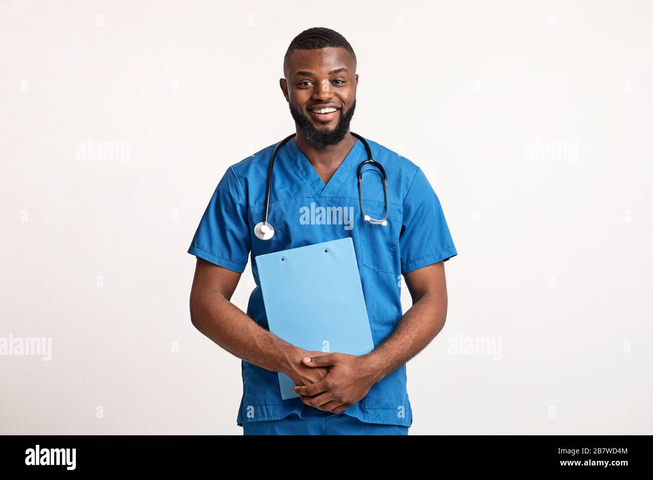 Handsome therapist in blue uniform making check up Stock Photo - Alamy