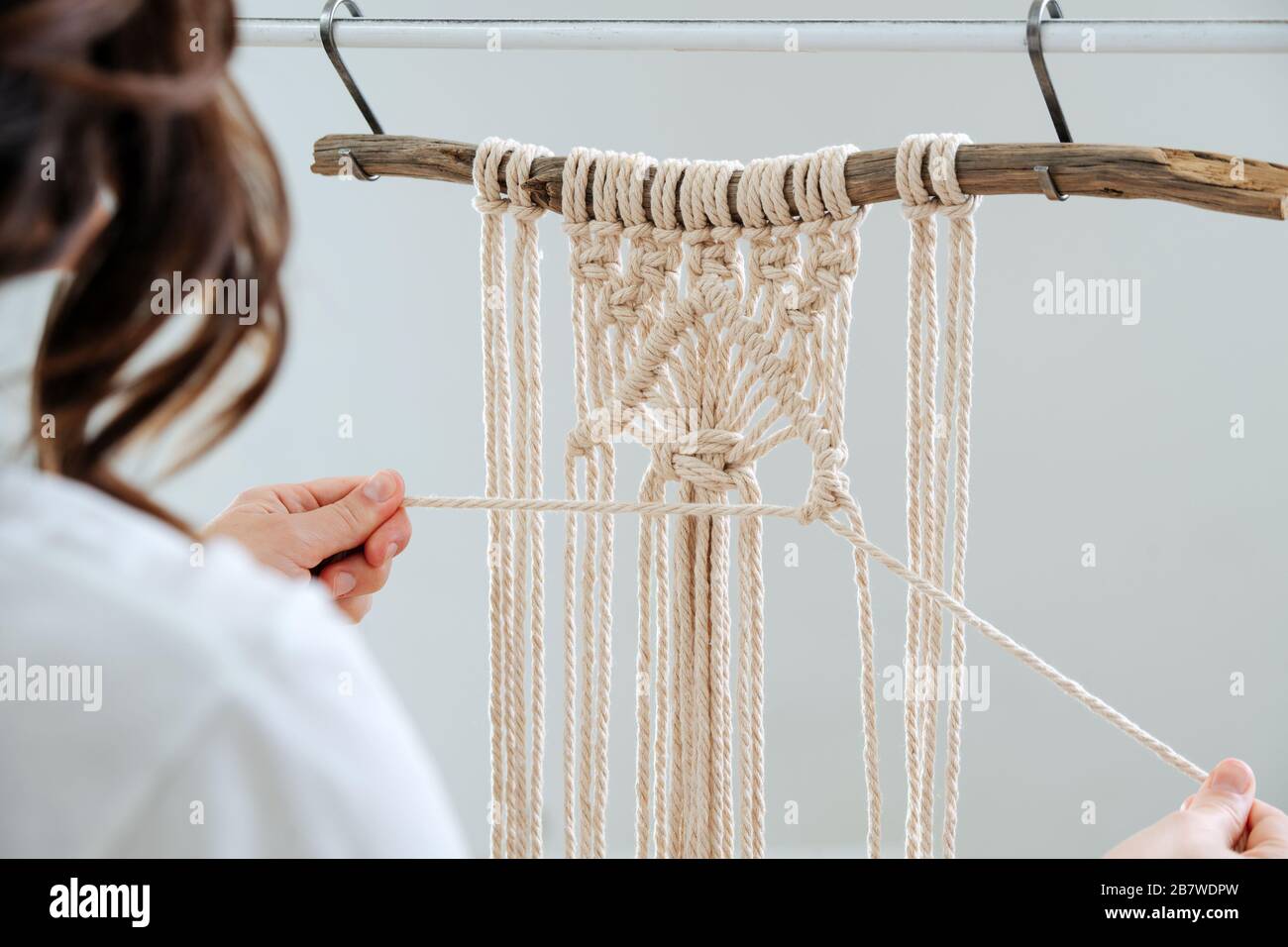 The base knots of macrame. Girl ties knots Stock Photo - Alamy