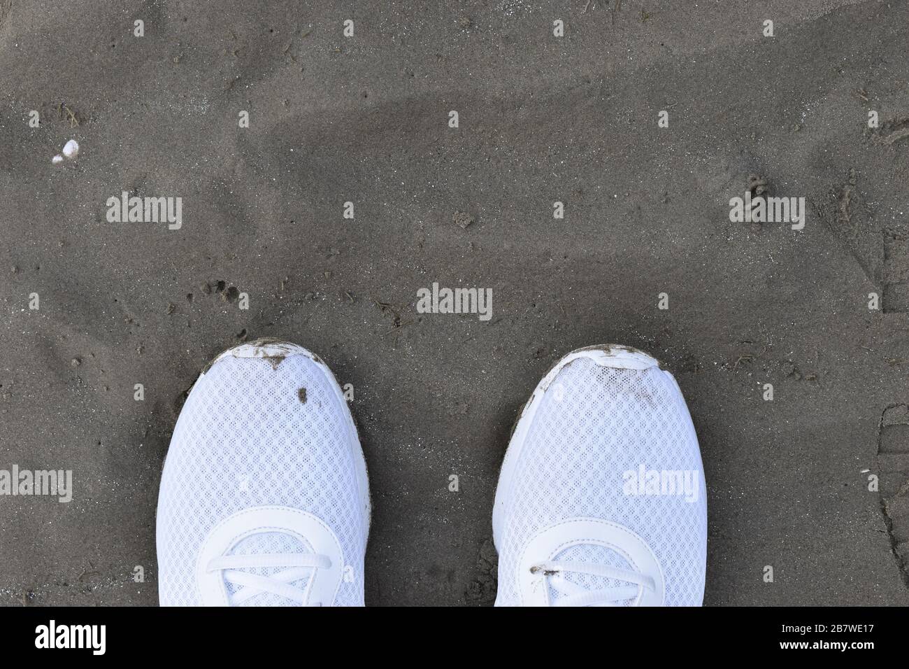 White Sneakers shoes walking on sand top view, running shoes walking on ...