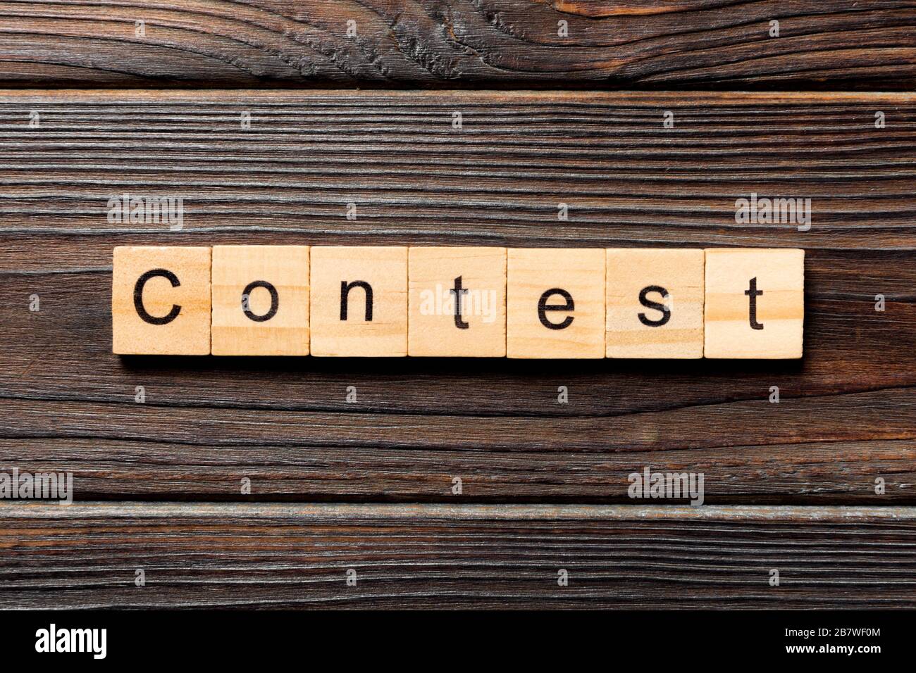 Contest word written on wood block. Contest text on wooden table for ...