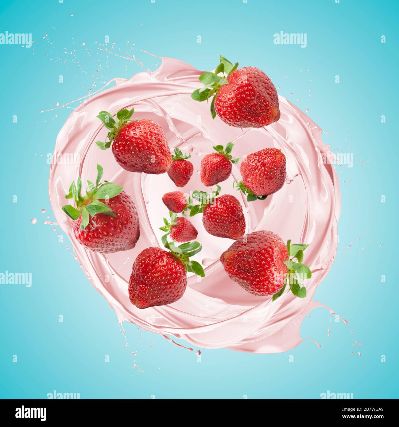 Strawberry milkshake splashing with fruits, on blue background Stock ...