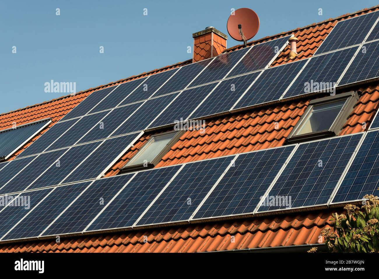 Solar panel on a red roof Stock Photo - Alamy