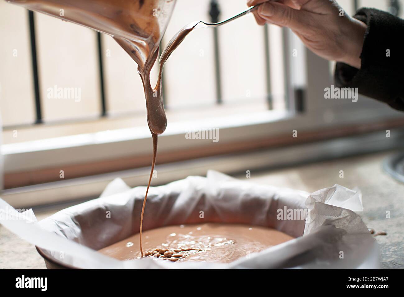 A close-up of chocolate milk liquid being poured into the form of a ...