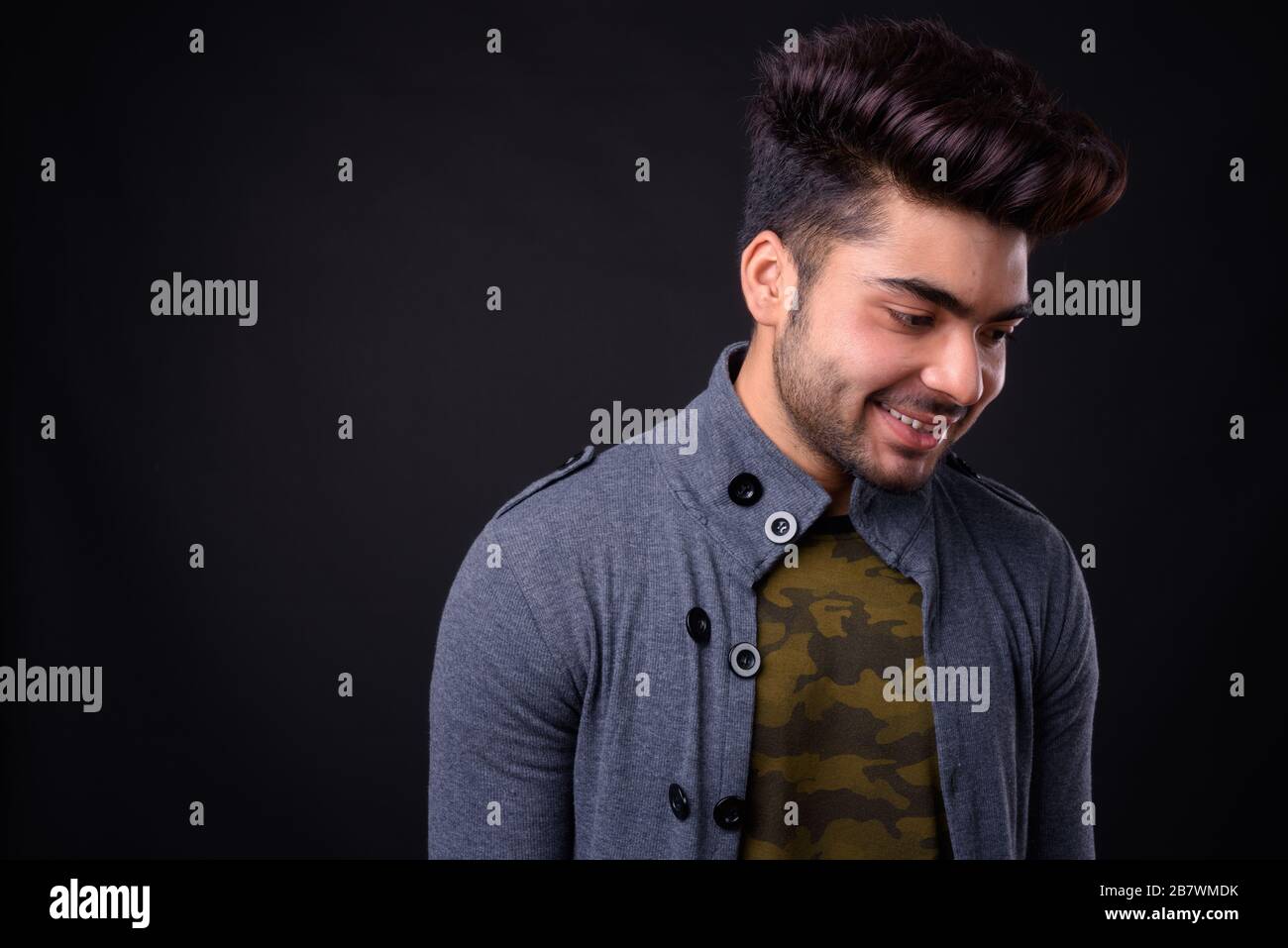Young handsome Indian man against black background Stock Photo - Alamy