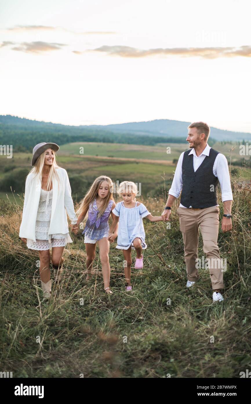 Happy family enjoying time together at summer sunset field outdoor ...