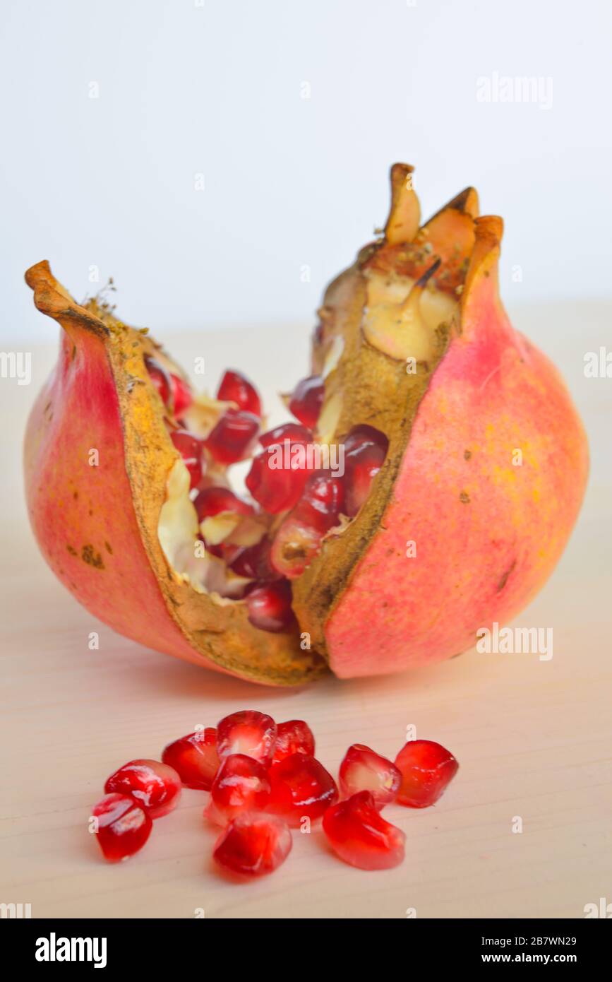 Some open pomegranate fruits are on a cutting board Stock Photo - Alamy