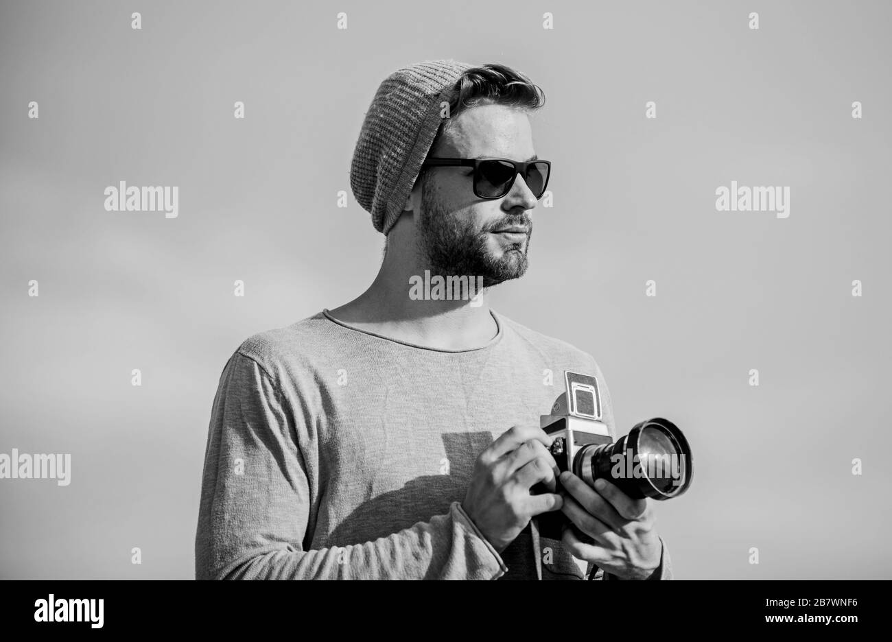 Hipster reporter taking photo. Guy photographer outdoors sky background ...