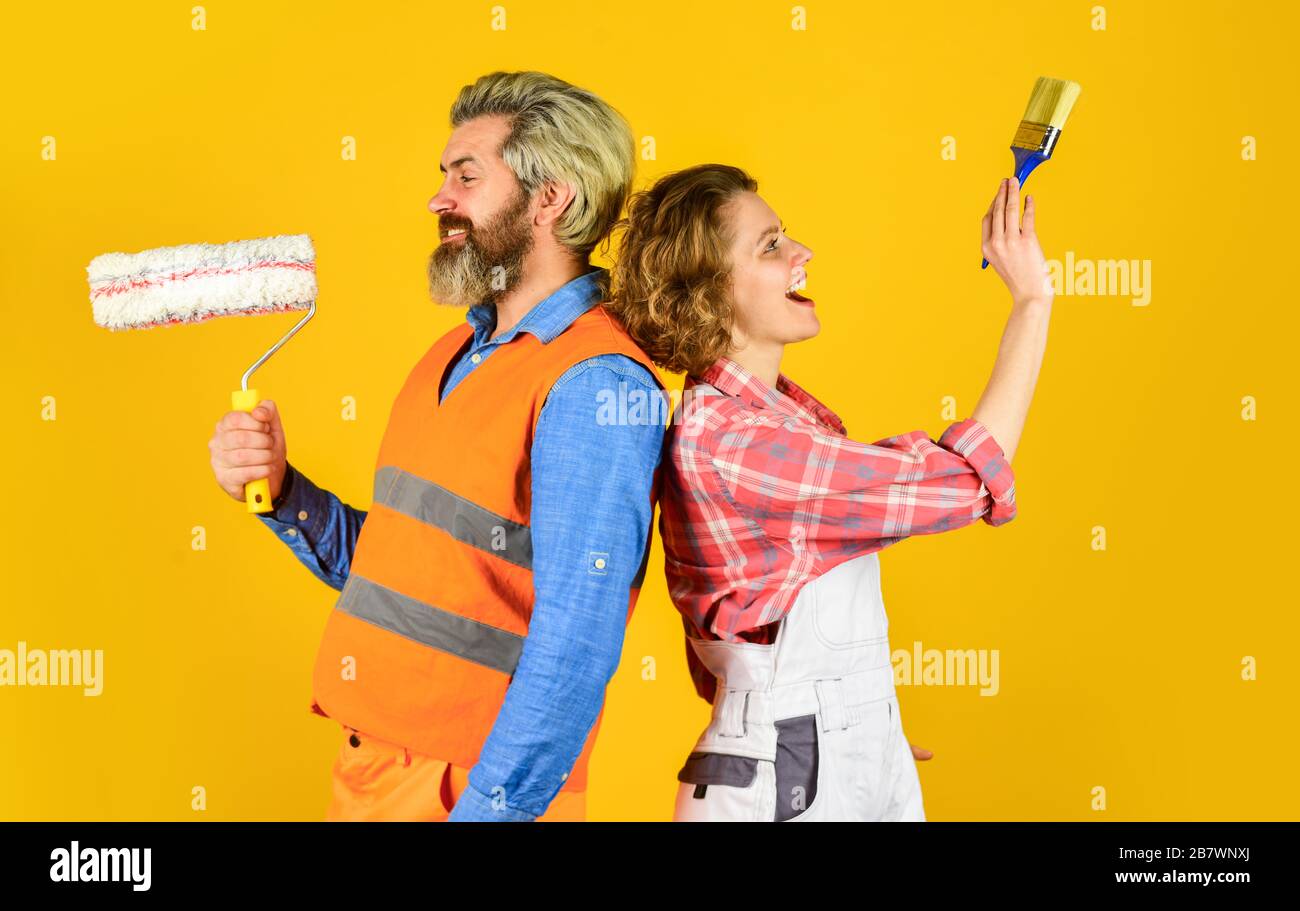 Painting walls. Woman builder. Man painter or decorator. Interior ...
