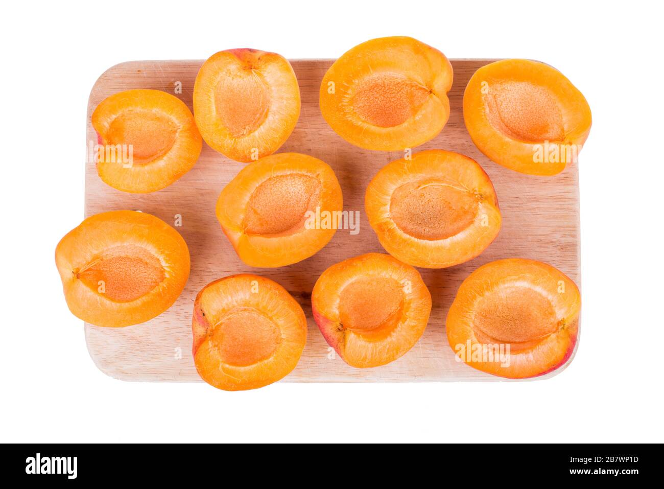apricots cut in halfs on the kitchen board Stock Photo - Alamy