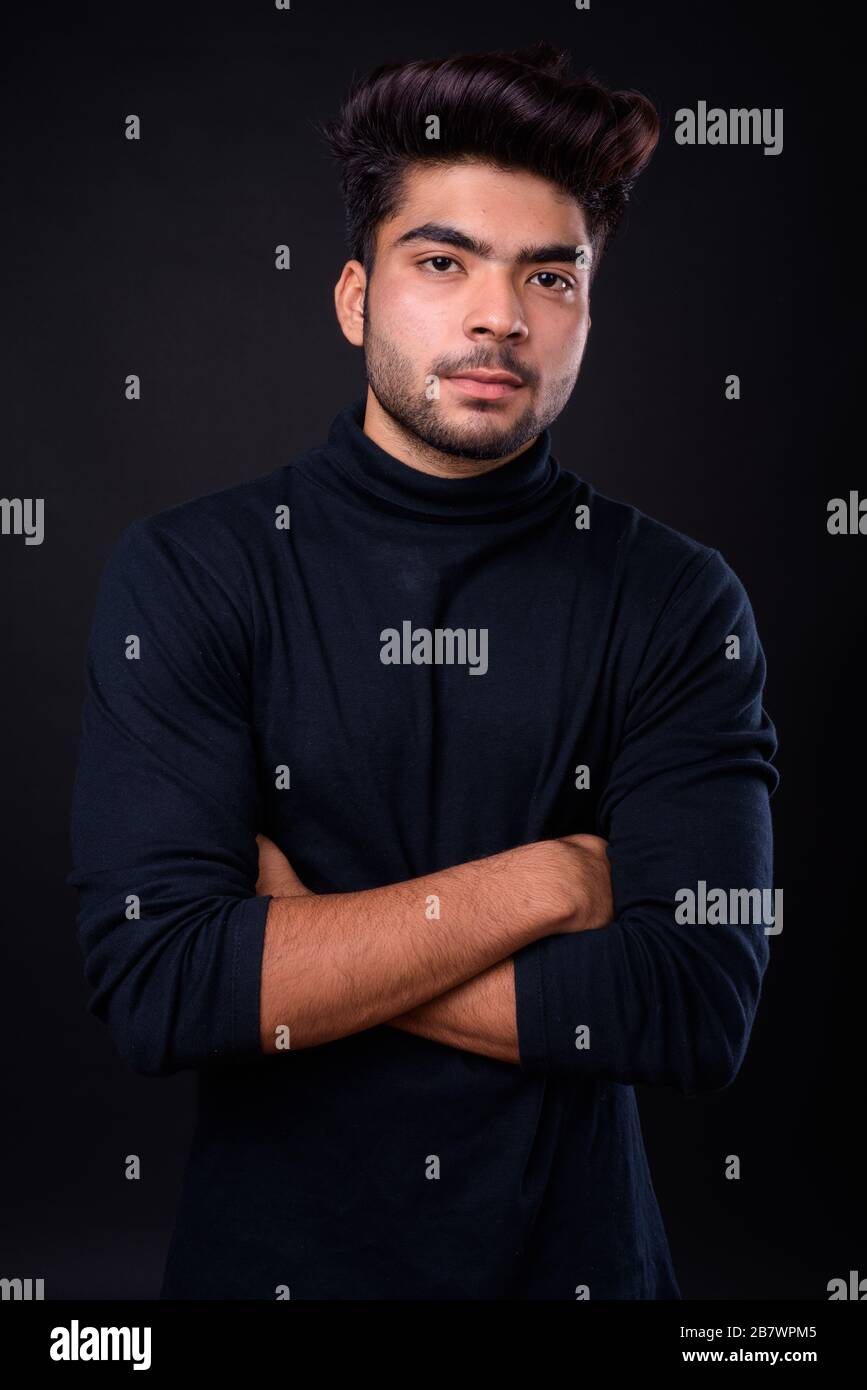 Young handsome Indian man against black background Stock Photo - Alamy