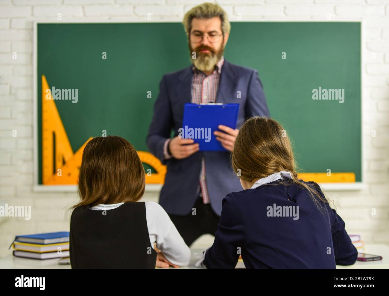 Really busy. back to school. Teacher and pupils working at desk ...