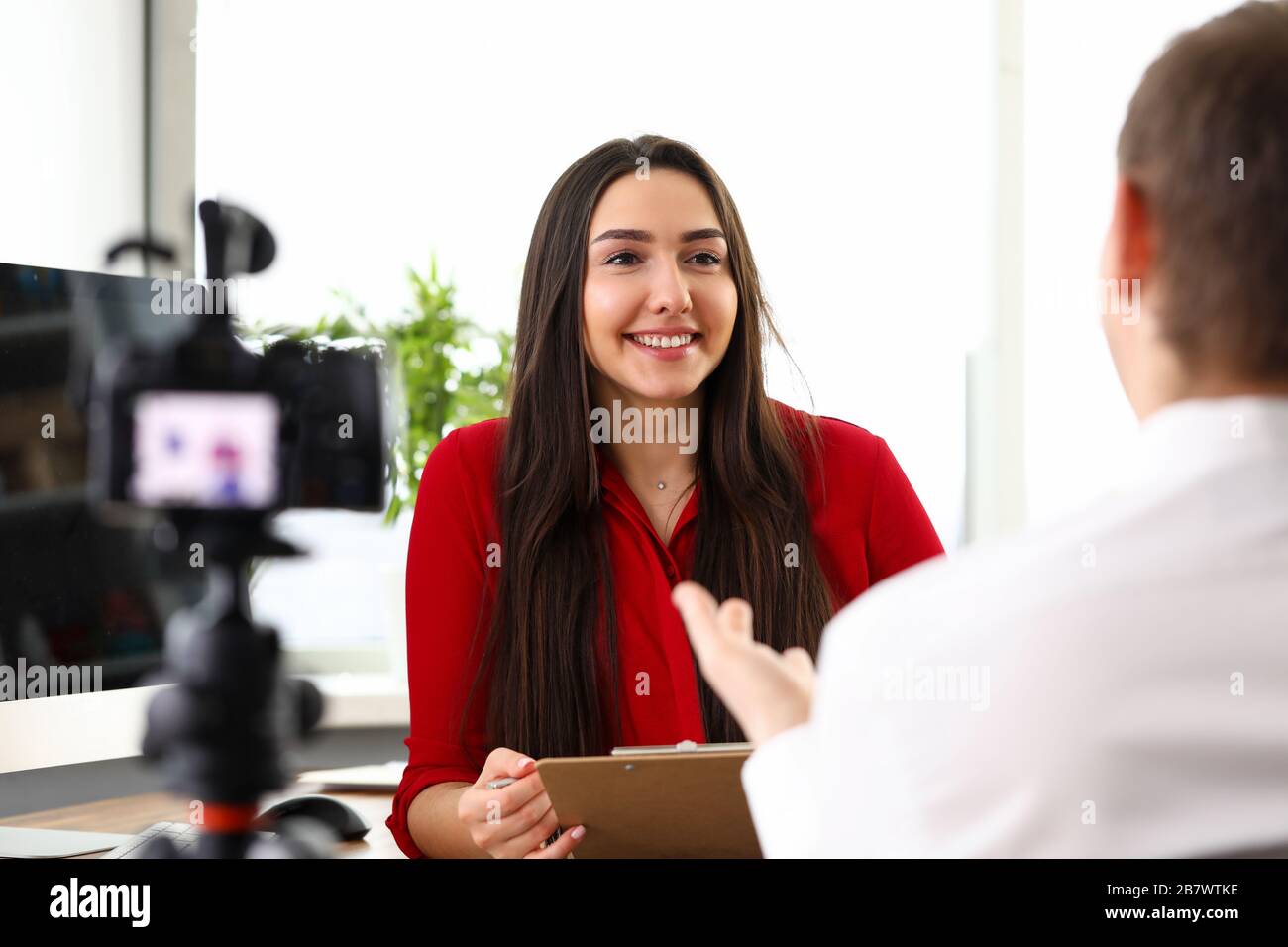 Young woman manager sitting in office and talking with colleague Stock ...