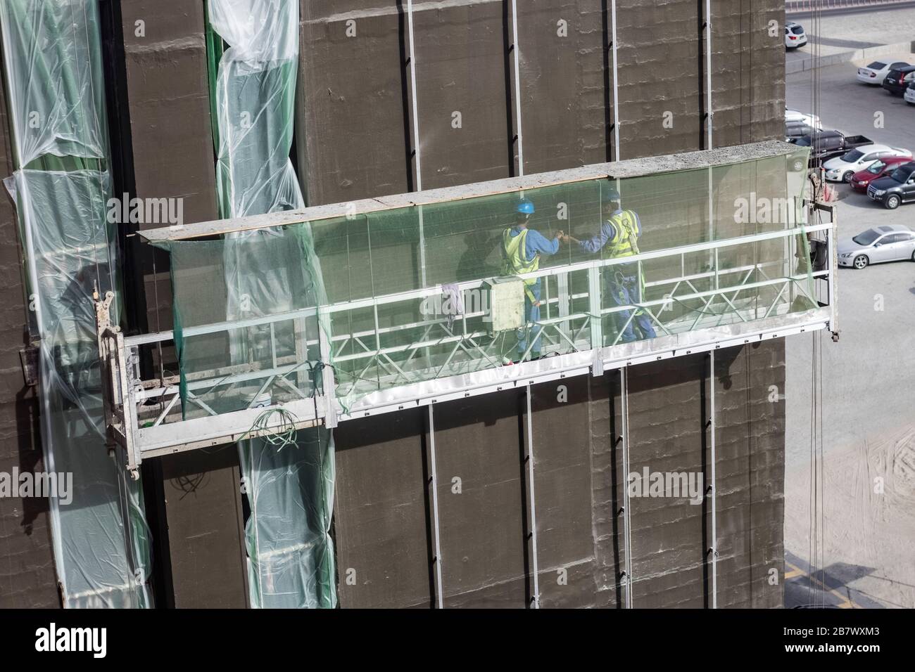 facade cladding of the building by the builders on an overhead crane ...