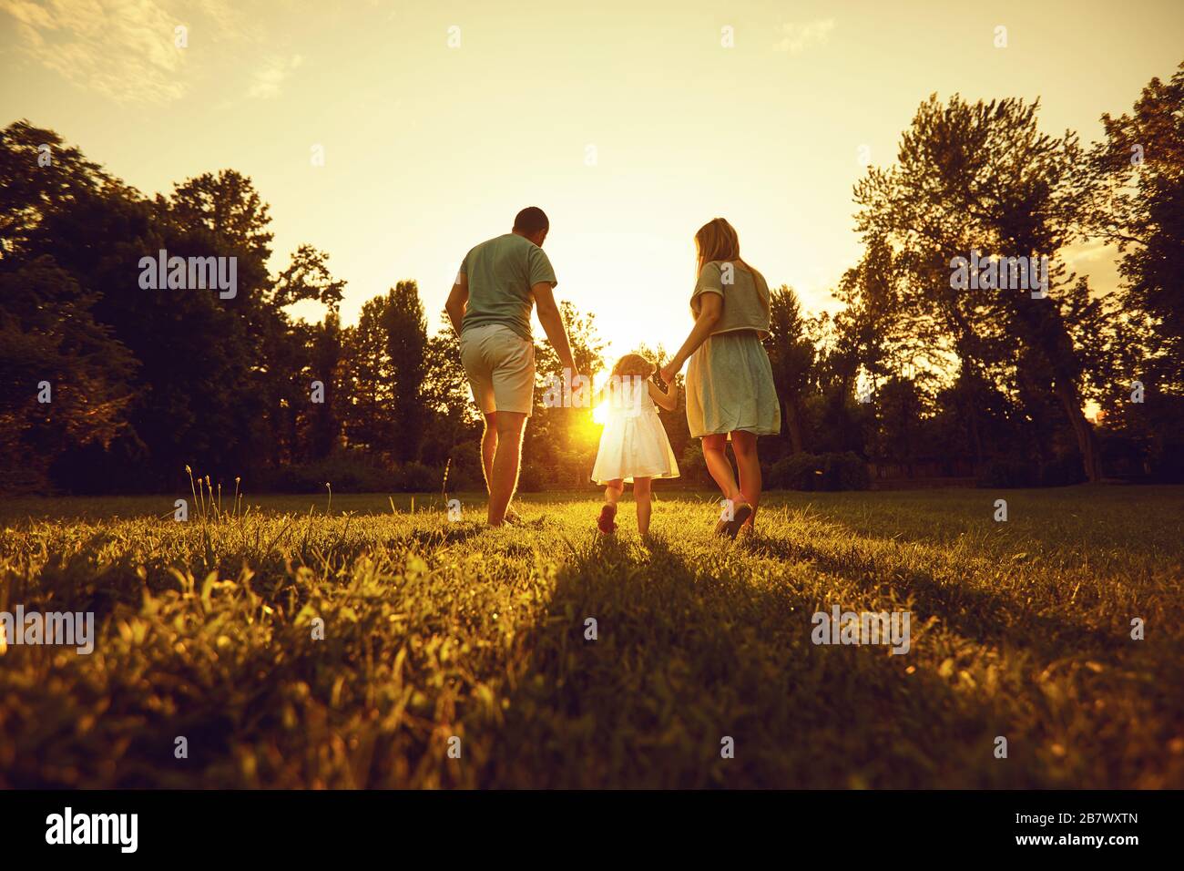 Happy parents with children in the park at sunset Stock Photo - Alamy