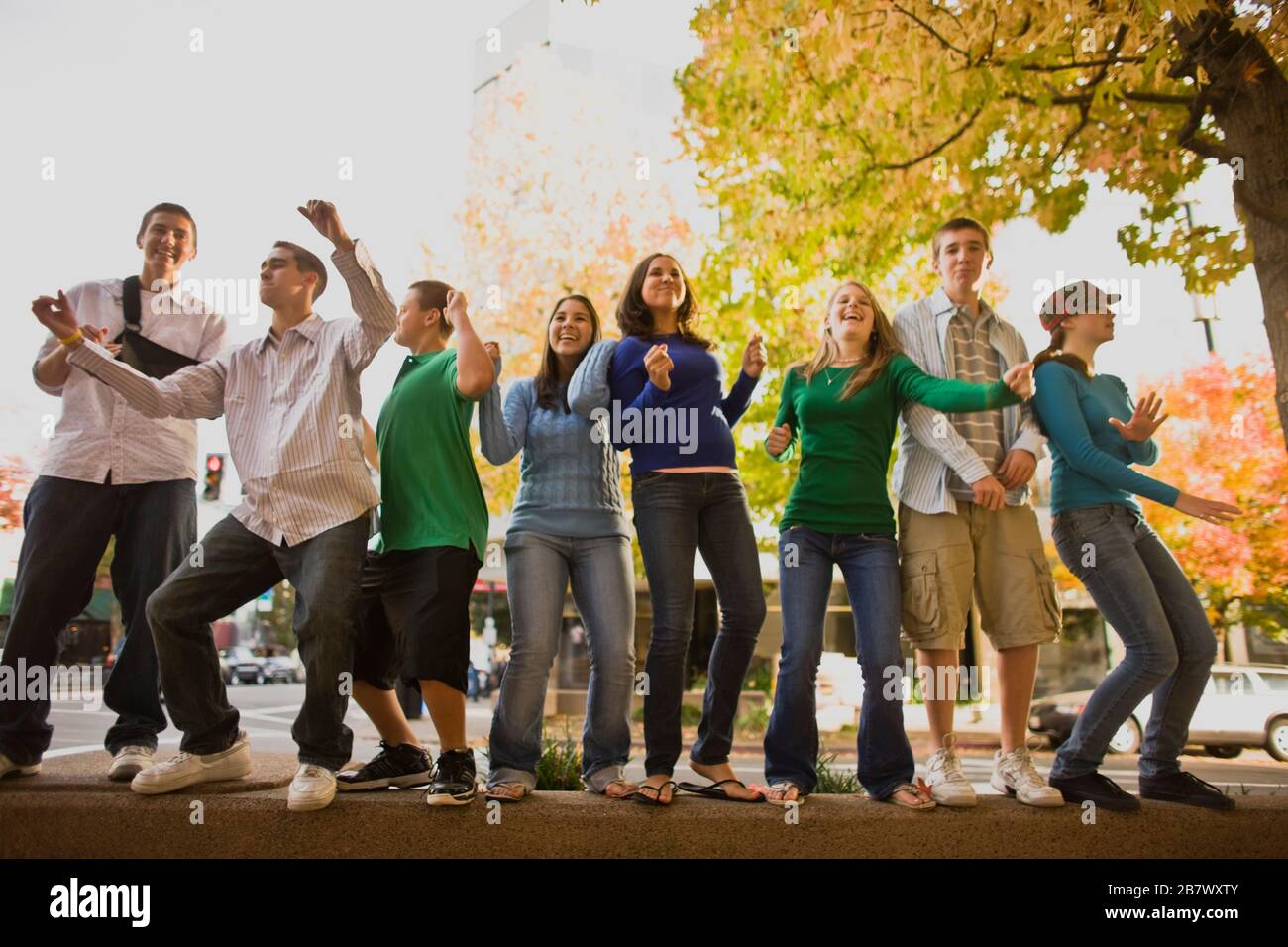 Friends dancing on ledge next to pavement Stock Photo - Alamy