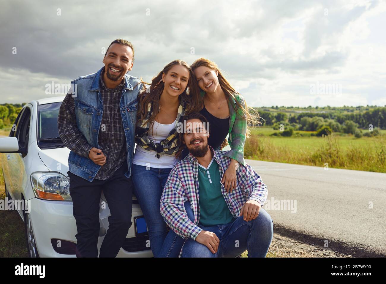 Group of people standing next travel in the car on road Stock Photo - Alamy