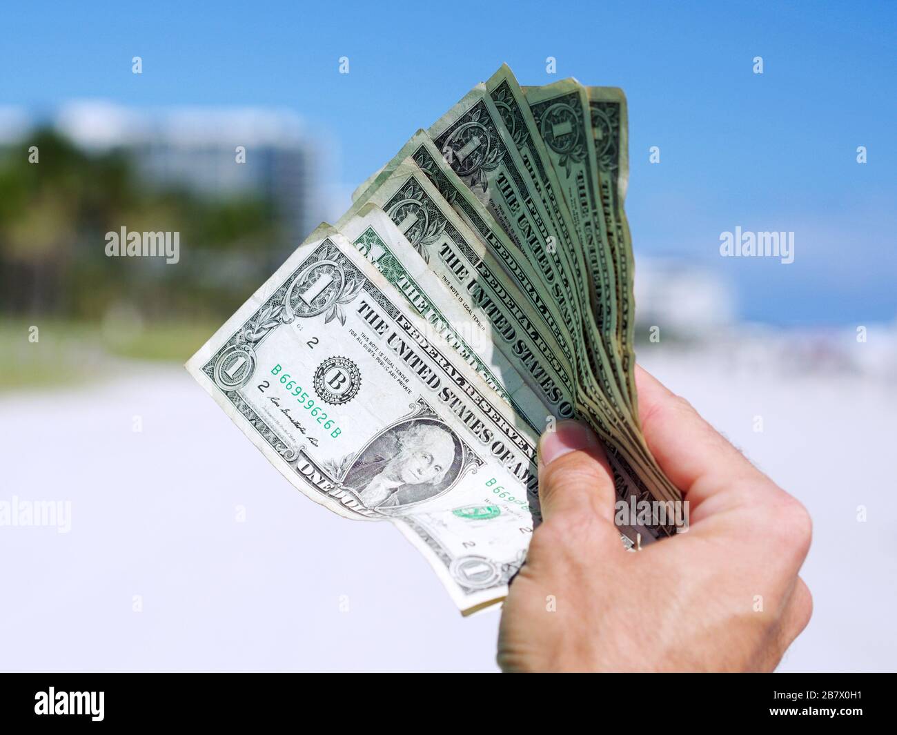 Dollar banknotes in a man nahd closeup in Miami beach, background.us ...